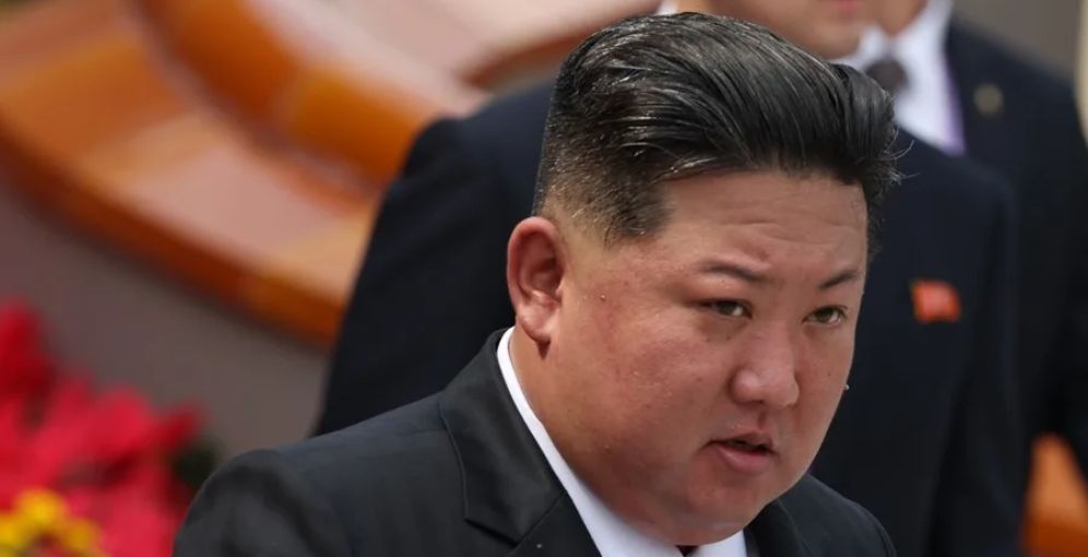 Kim y el representante de Seúl se saludan en el desfile de Pekín